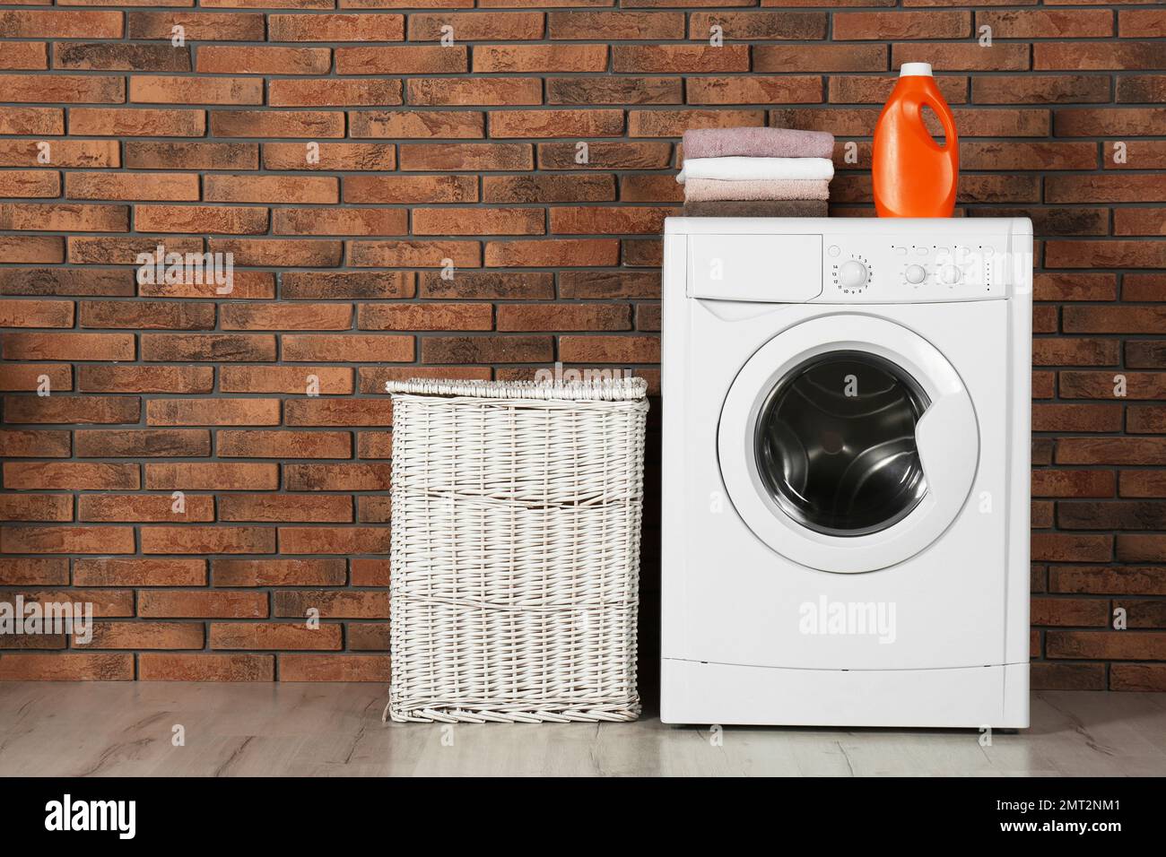 Modern washing machine with stack of towels, detergent and laundry ...