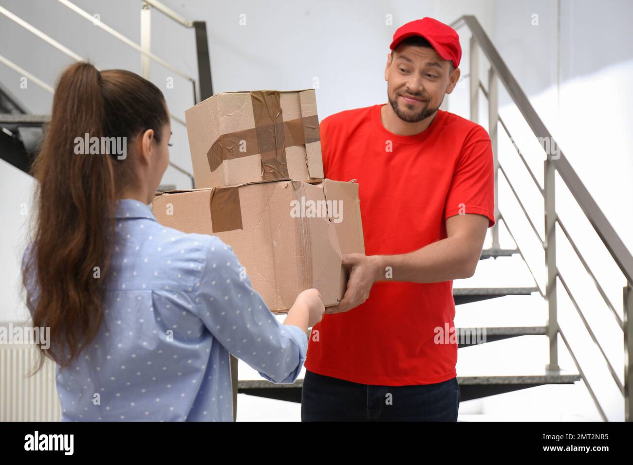 Emotional courier giving damaged cardboard boxes to client indoors ...