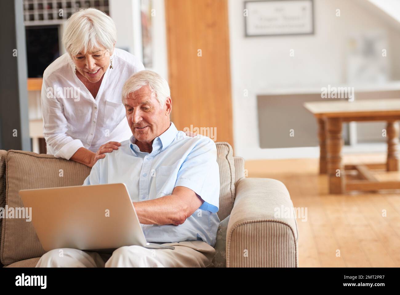Catching up on the news online. a senior woman standing behind her ...