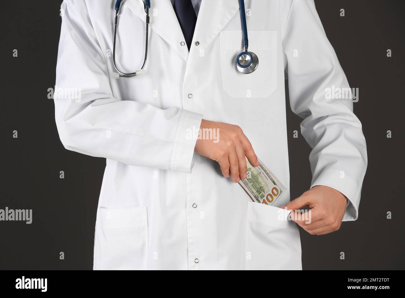 Doctor putting bribe into pocket on black background, closeup ...