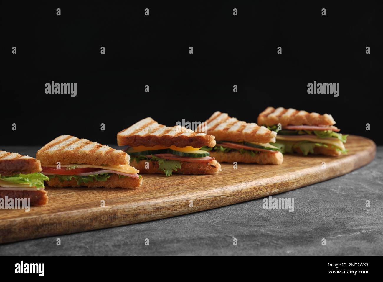 Tasty sandwiches with ham on grey table Stock Photo - Alamy