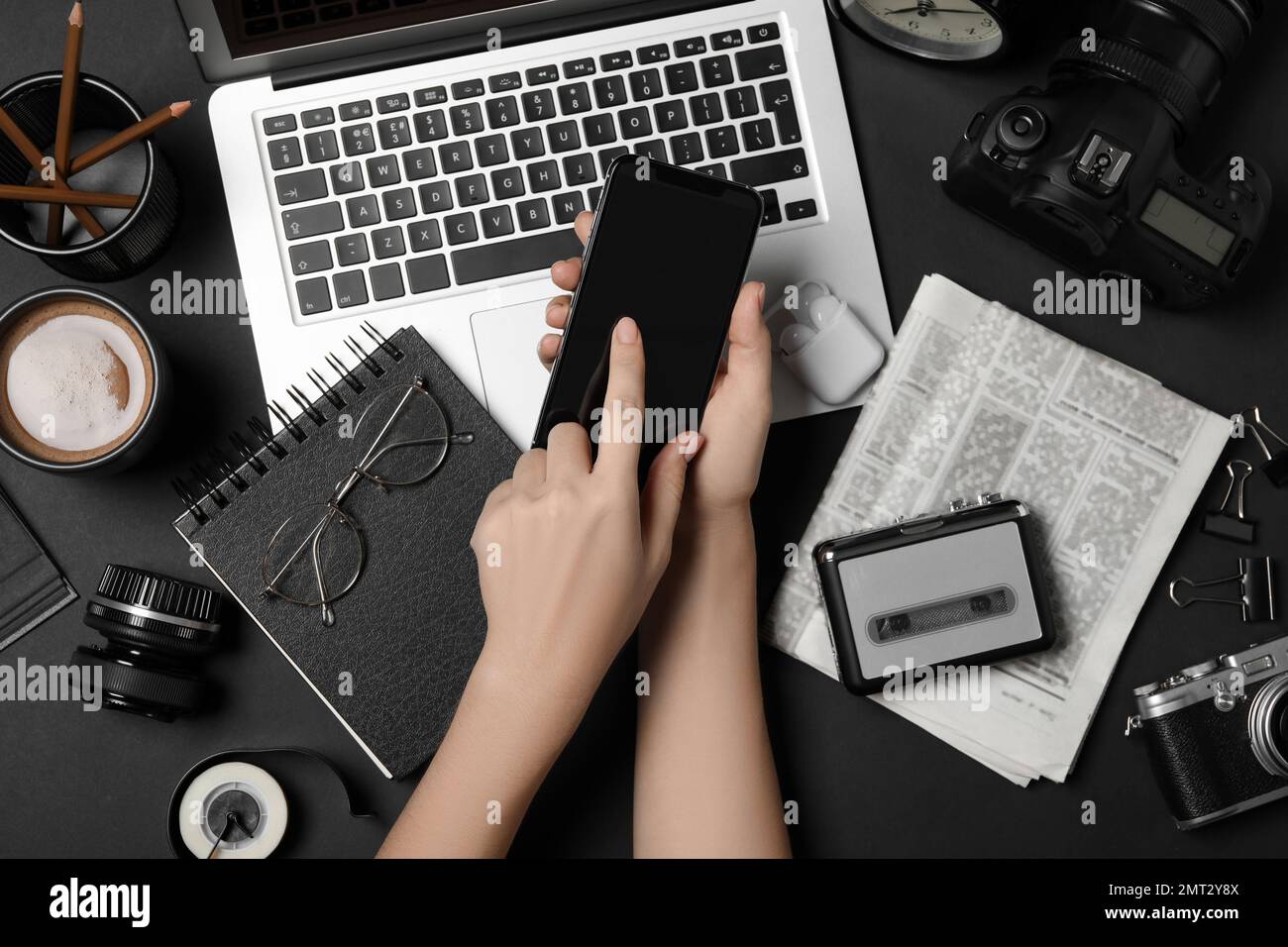 Journalist with smartphone working at black table, top view Stock Photo ...