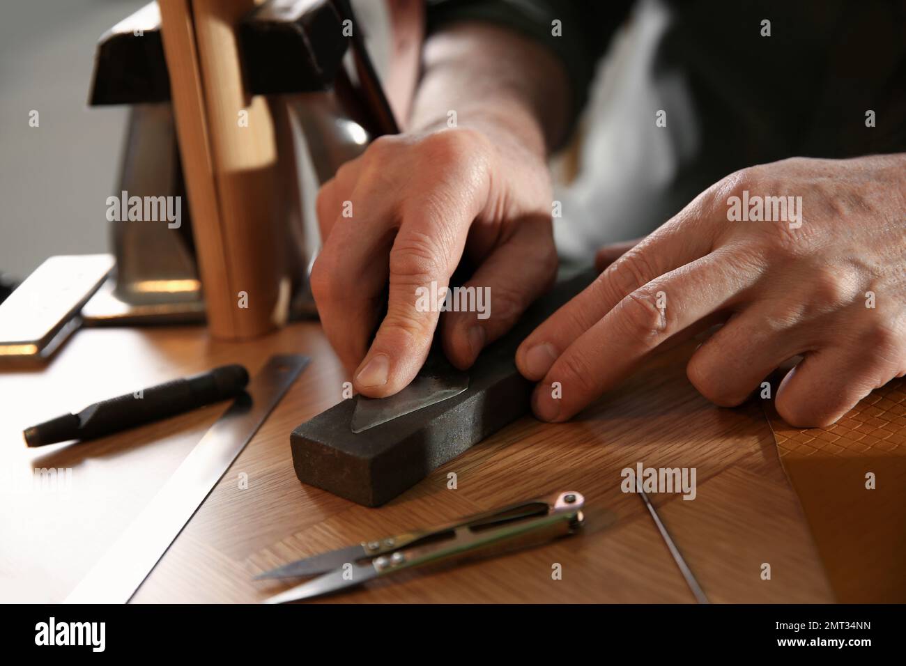 Man with tools for leather working, closeup Stock Photo - Alamy
