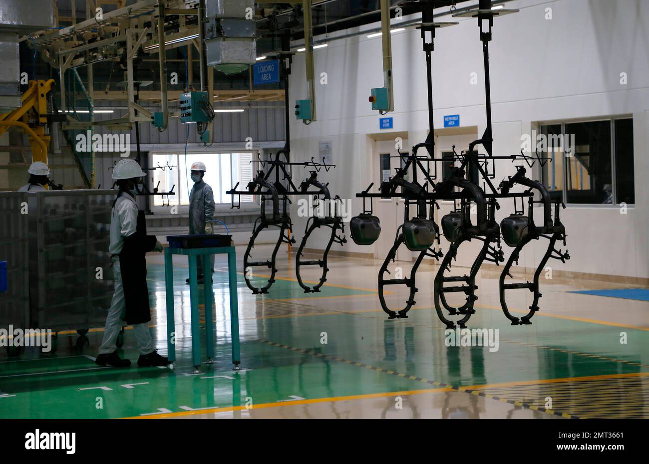 Iron frames made for Honda Activa scooters hang at an assembly line of ...