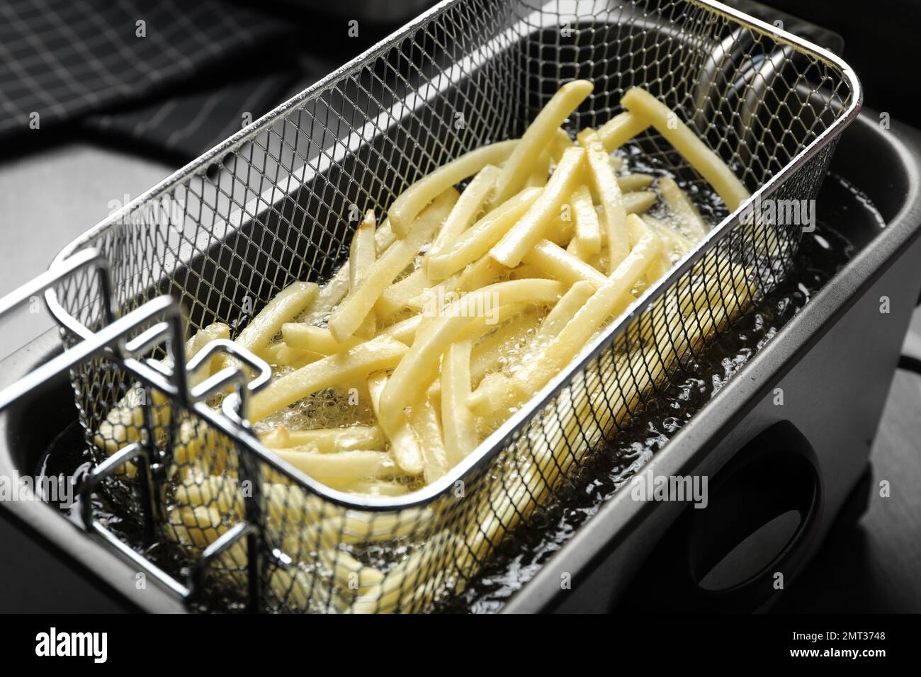 Cooking delicious french fries in hot oil, closeup Stock Photo - Alamy