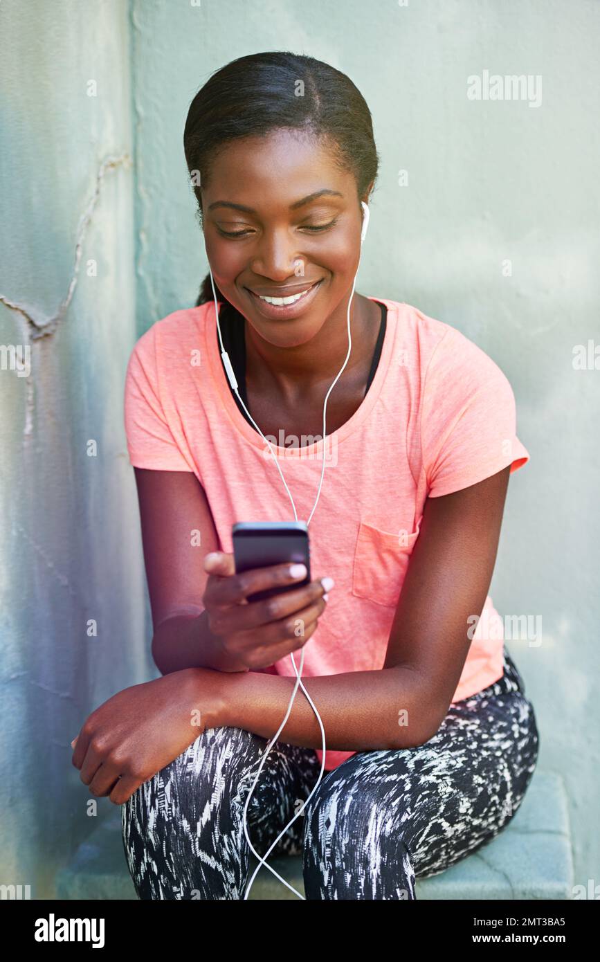 Music motivates her. an attractive young woman listening to music while ...