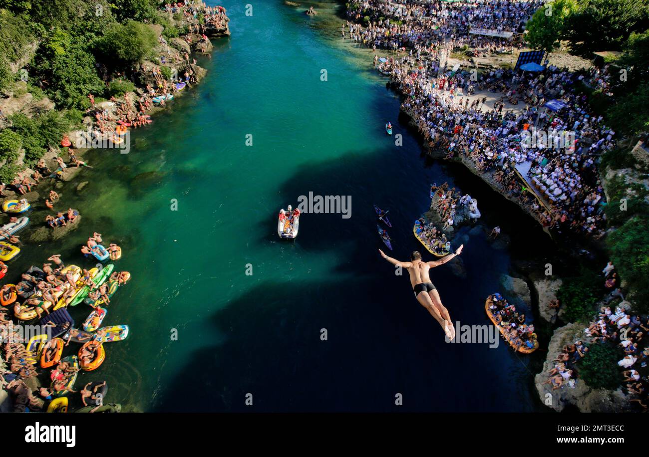 In this photograph taken on Sunday, July 30, 2017, a man dives from the ...