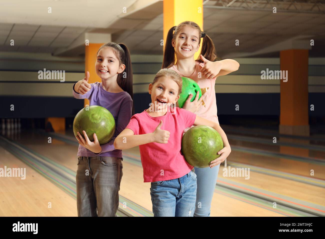 Happy girls with balls in bowling club Stock Photo - Alamy