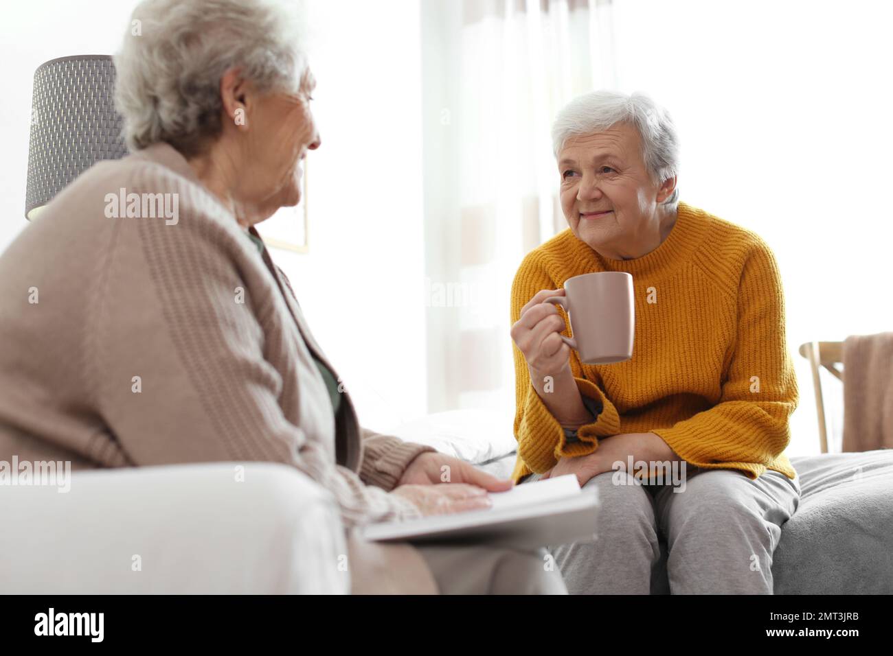 Elderly women spending time together in bedroom. Senior people care ...