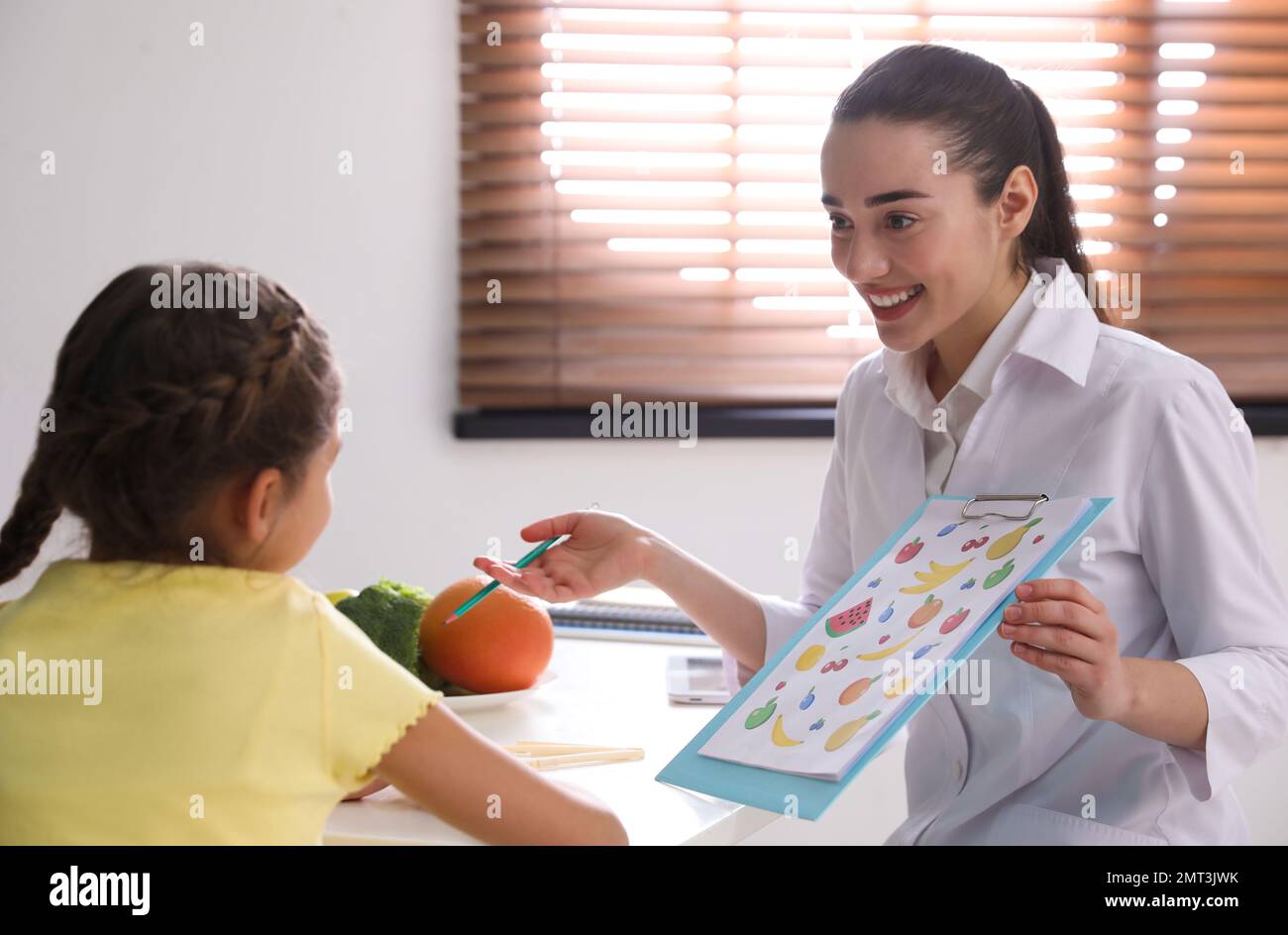 Little girl visiting professional nutritionist in office Stock Photo ...