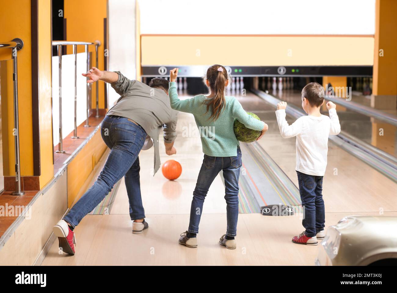 Happy family spending time together in bowling club Stock Photo - Alamy