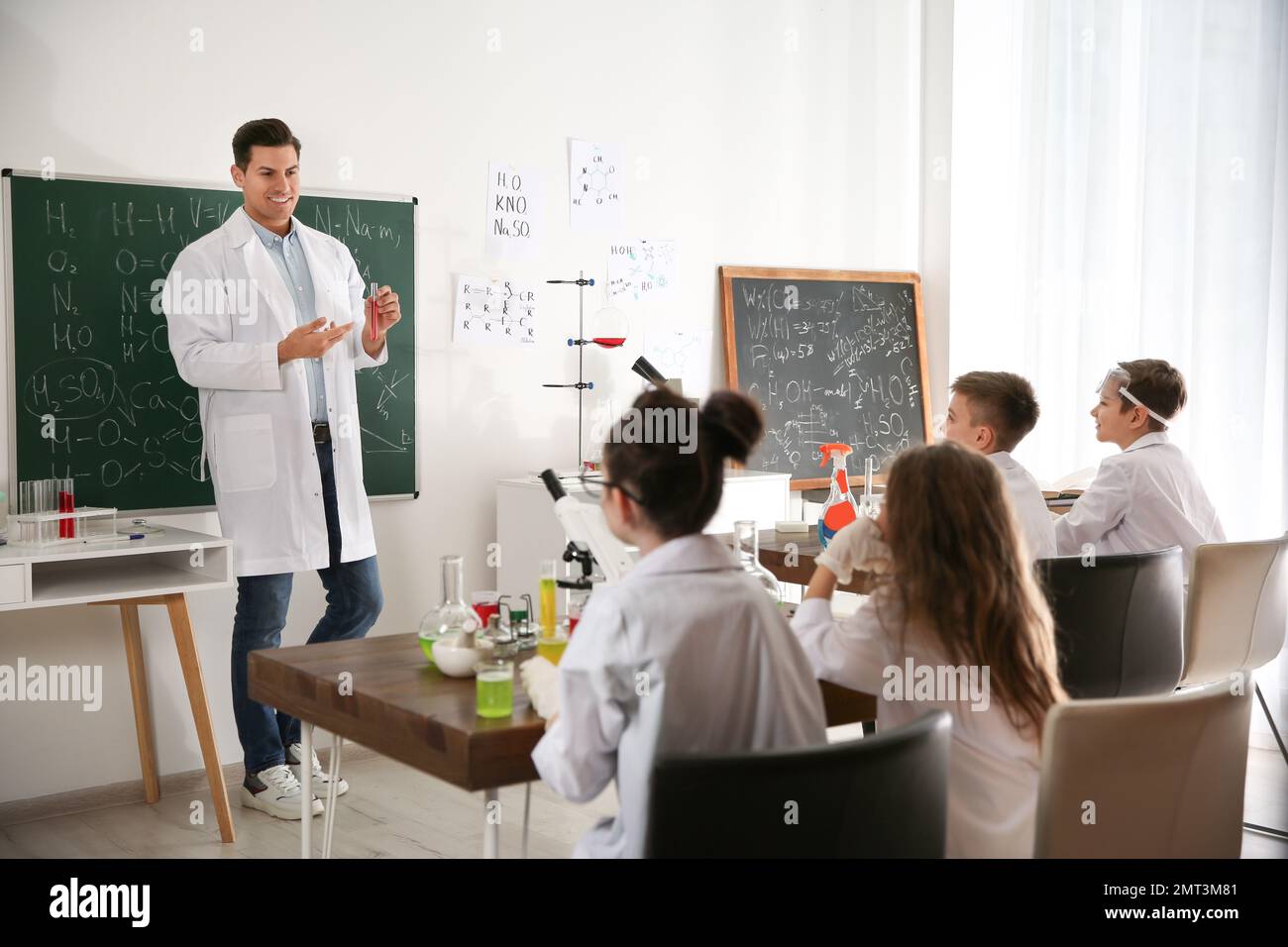 Teacher with pupils at chemistry lesson in classroom Stock Photo - Alamy