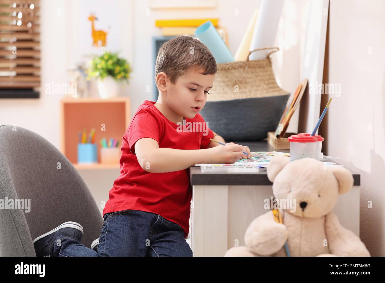 Little child painting at table in room Stock Photo - Alamy