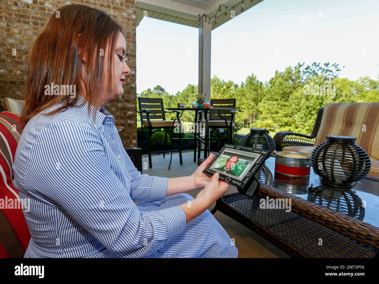Candy Cheatham, daughter of murder victim Cole Cannon, holds a photo of ...
