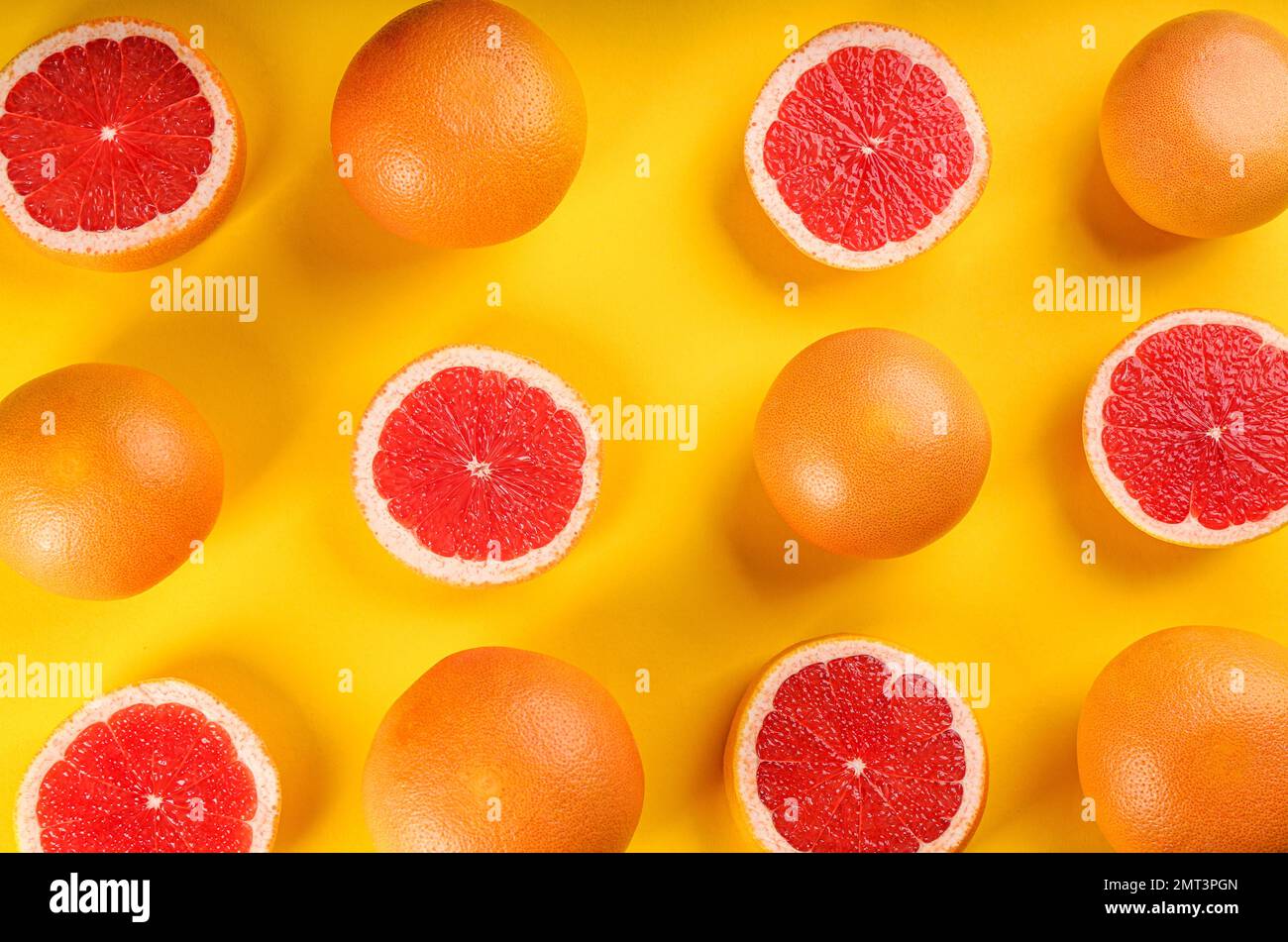 Cut and whole ripe grapefruits on yellow background, flat lay Stock ...