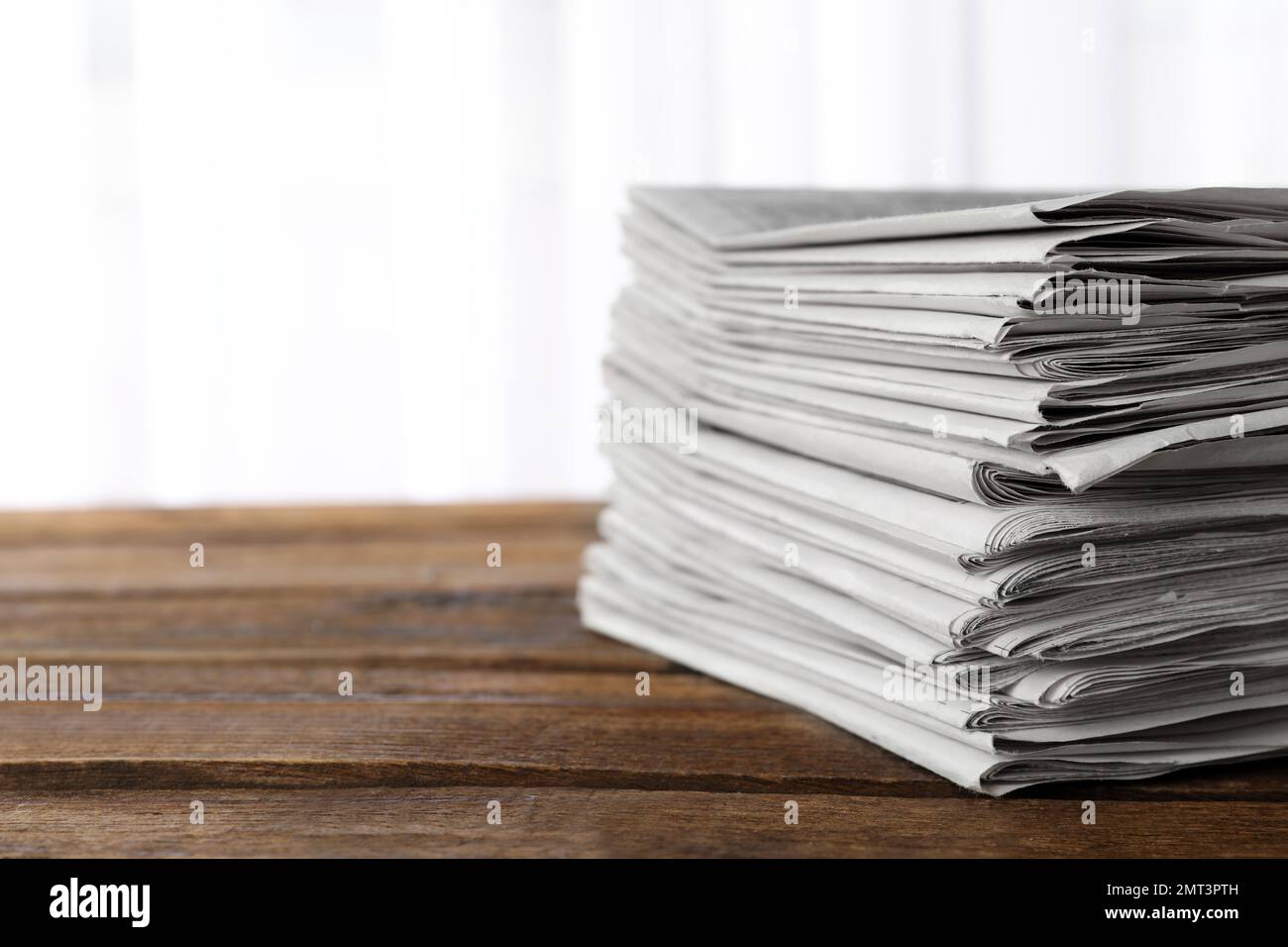 Stack of newspapers on wooden table, space for text. Journalist's work ...