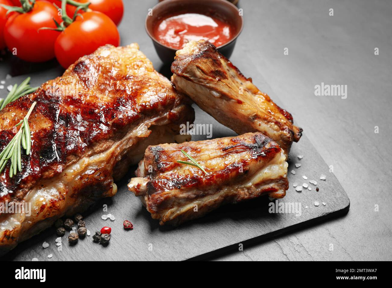 Delicious grilled ribs on black table, closeup Stock Photo - Alamy