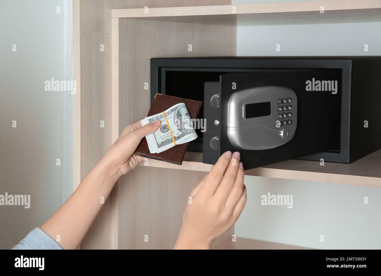 Woman putting passport and money into steel safe, closeup Stock Photo ...