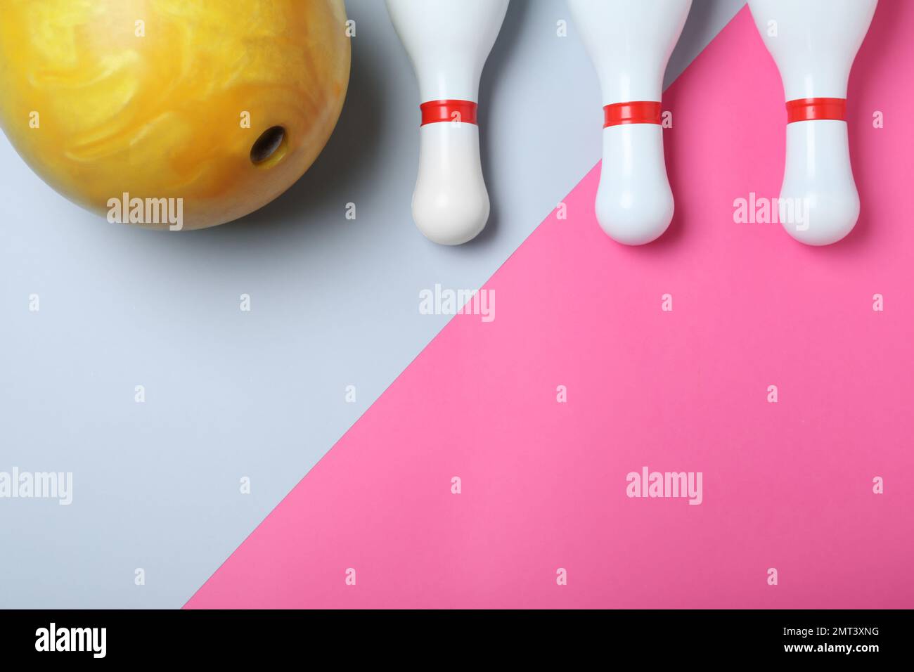 Bowling ball and pins on color background, flat lay. Space for text ...