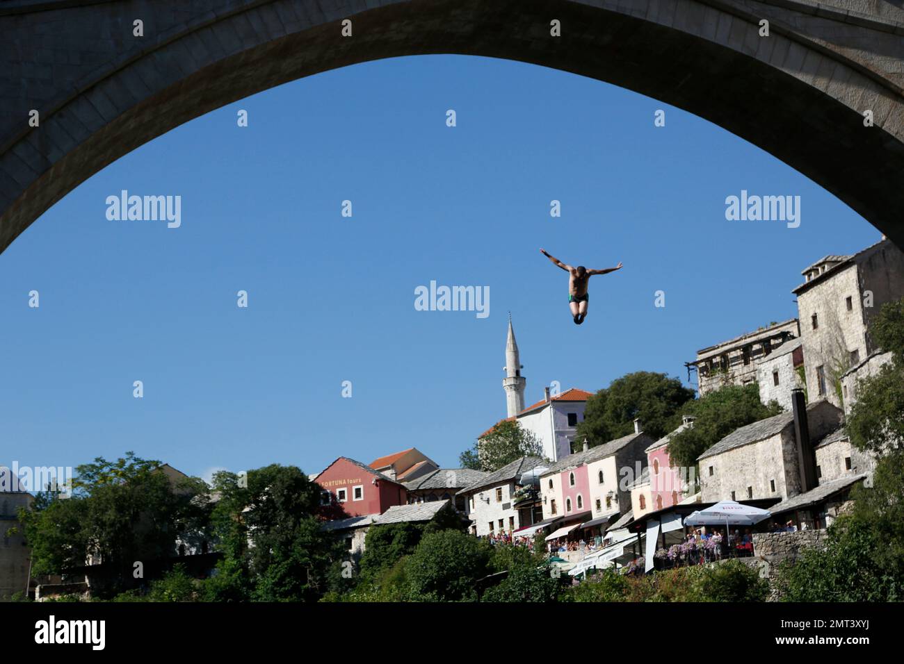 A diver drops through the air from the Mostar bridge during 451th ...