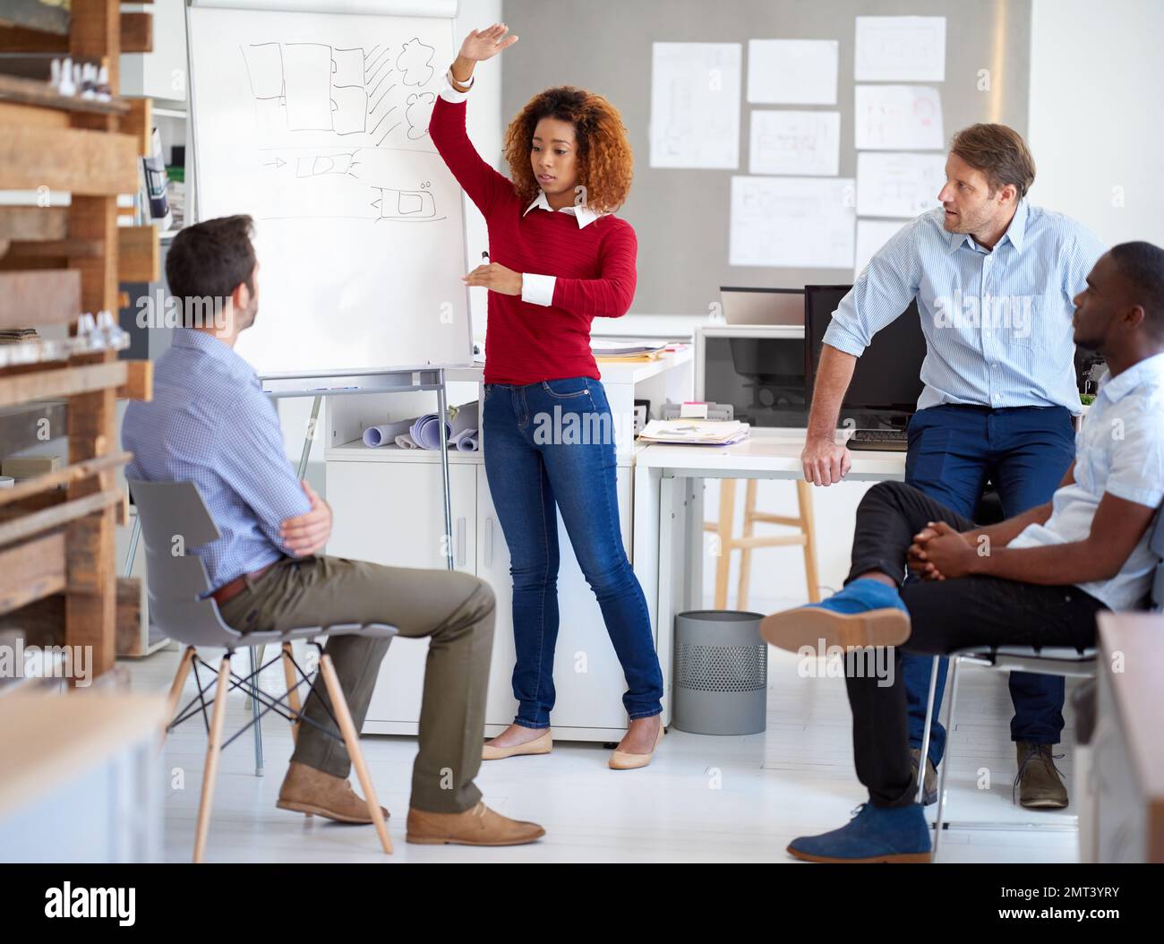 Putting their heads together for a quick meeting. a group of designers talking together in a ...