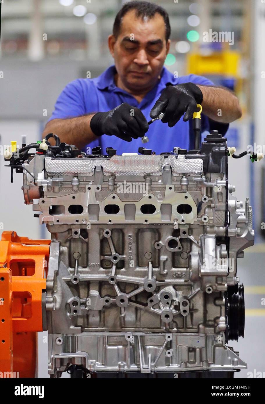 A Ford employee assembles a two liter diesel engine, called panther ...