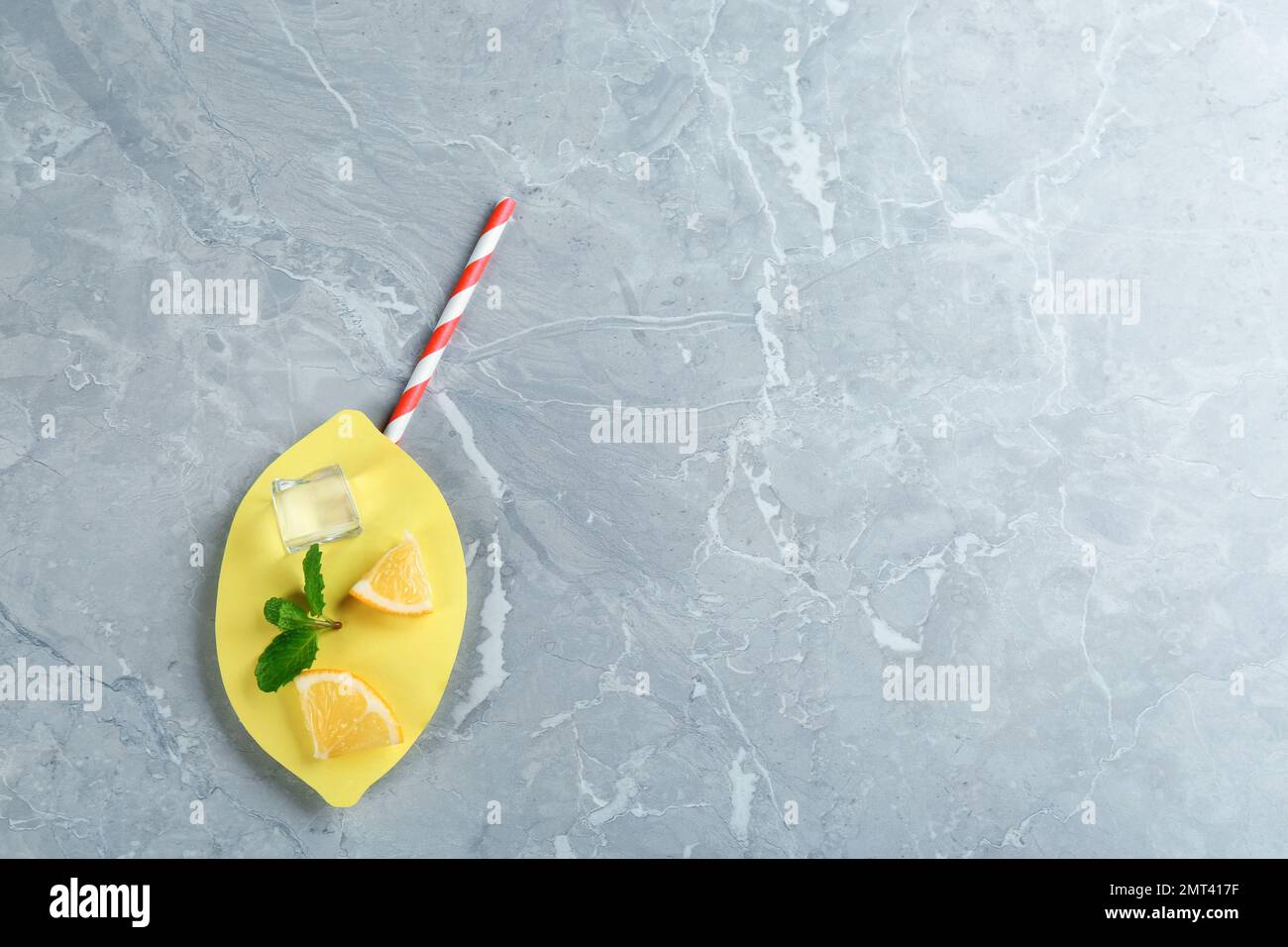 Creative lemonade layout with lemon slices, mint and ice on grey marble ...