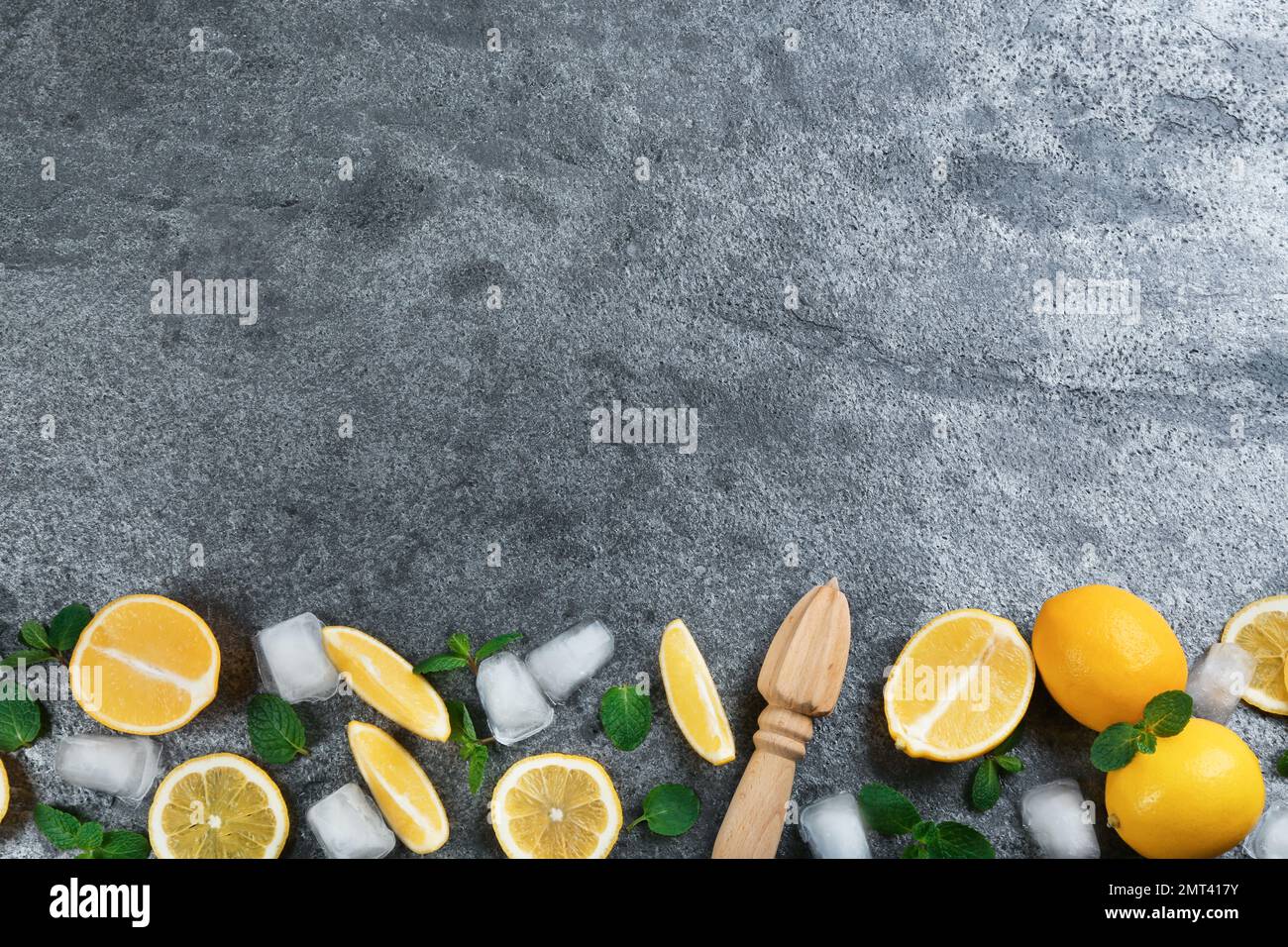 Lemonade layout with juicy lemon slices, mint and ice cubes on grey ...