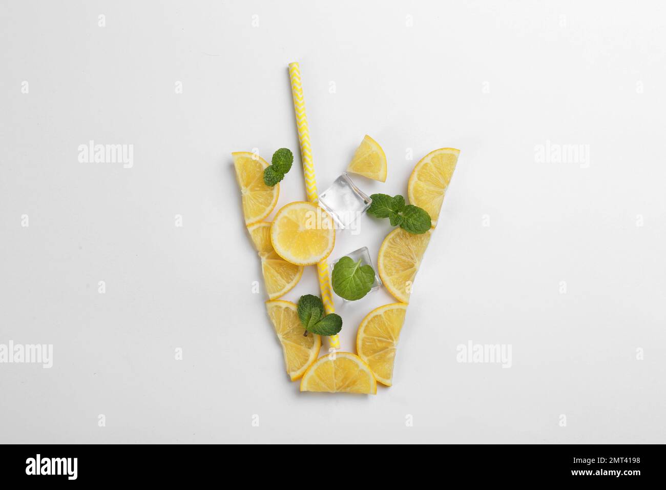 Creative lemonade layout with lemon slices, straw, ice cubes and mint on white background, top ...