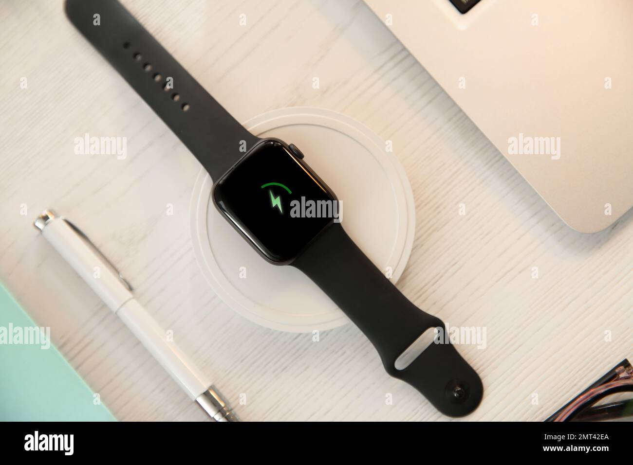 Flat lay composition with smartwatch and wireless charger on white ...