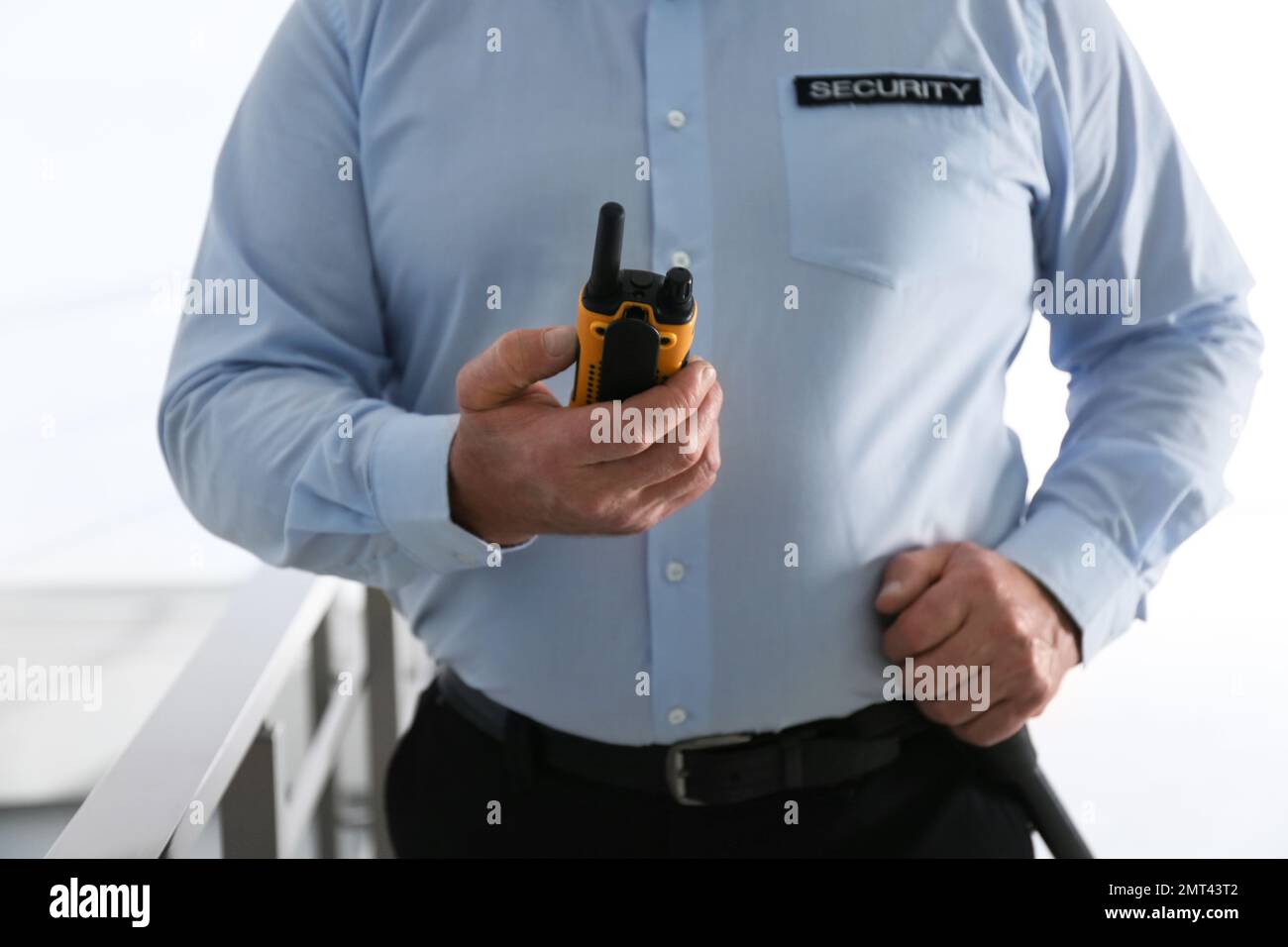 Professional security guard with portable radio set indoors, closeup ...