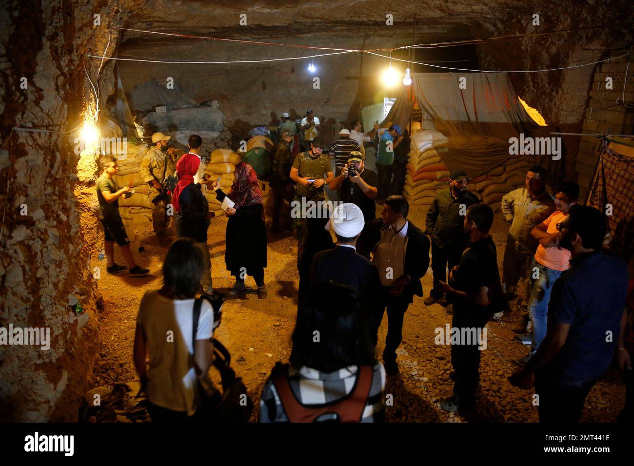 Hezbollah fighters and journalists stand inside a cave during a tour by ...