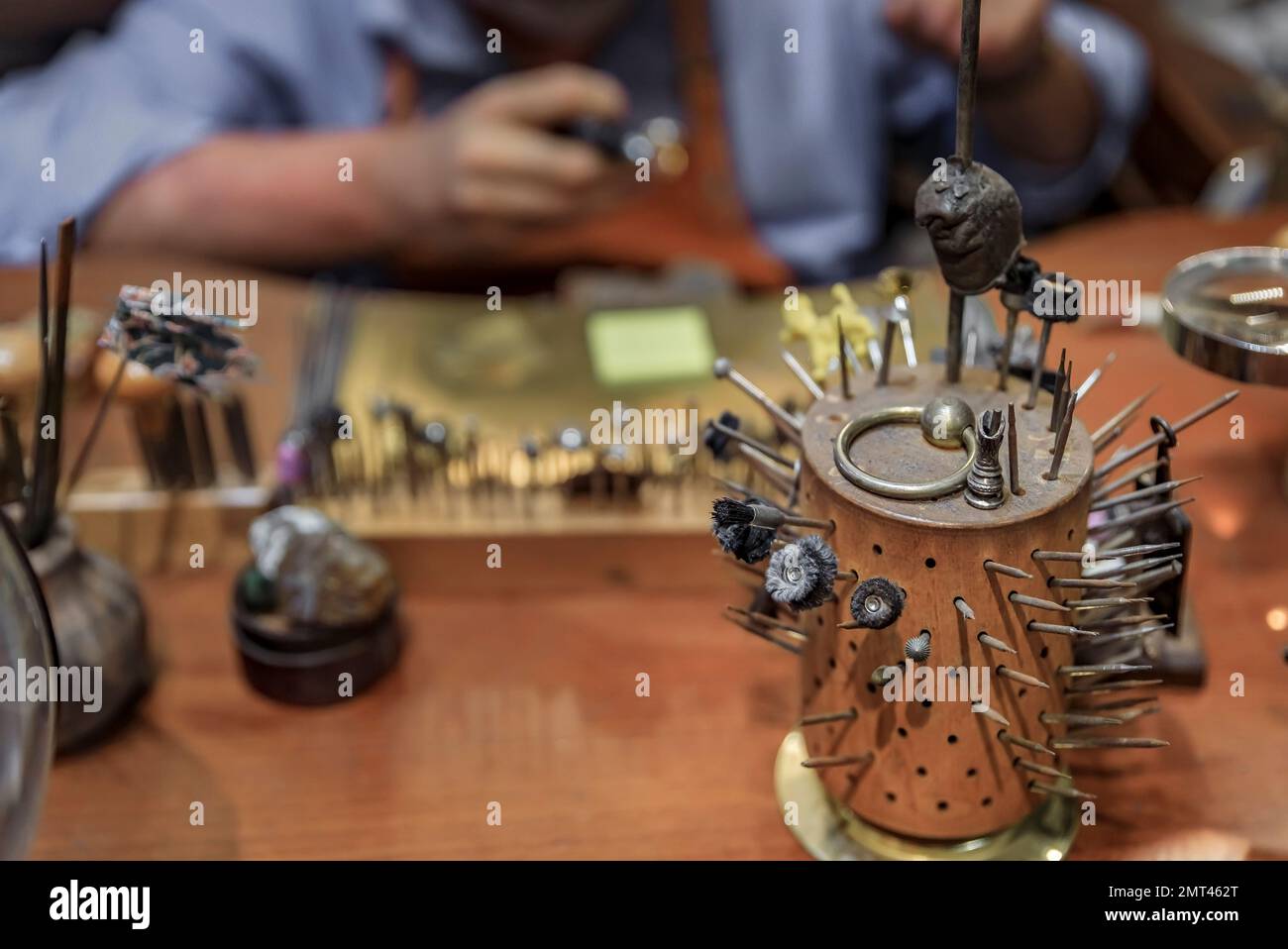 Silversmith working with tools on a jewelers bench in a traditional ...