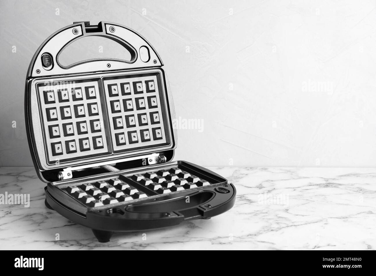 Modern waffle iron on white marble table. Space for text Stock Photo ...