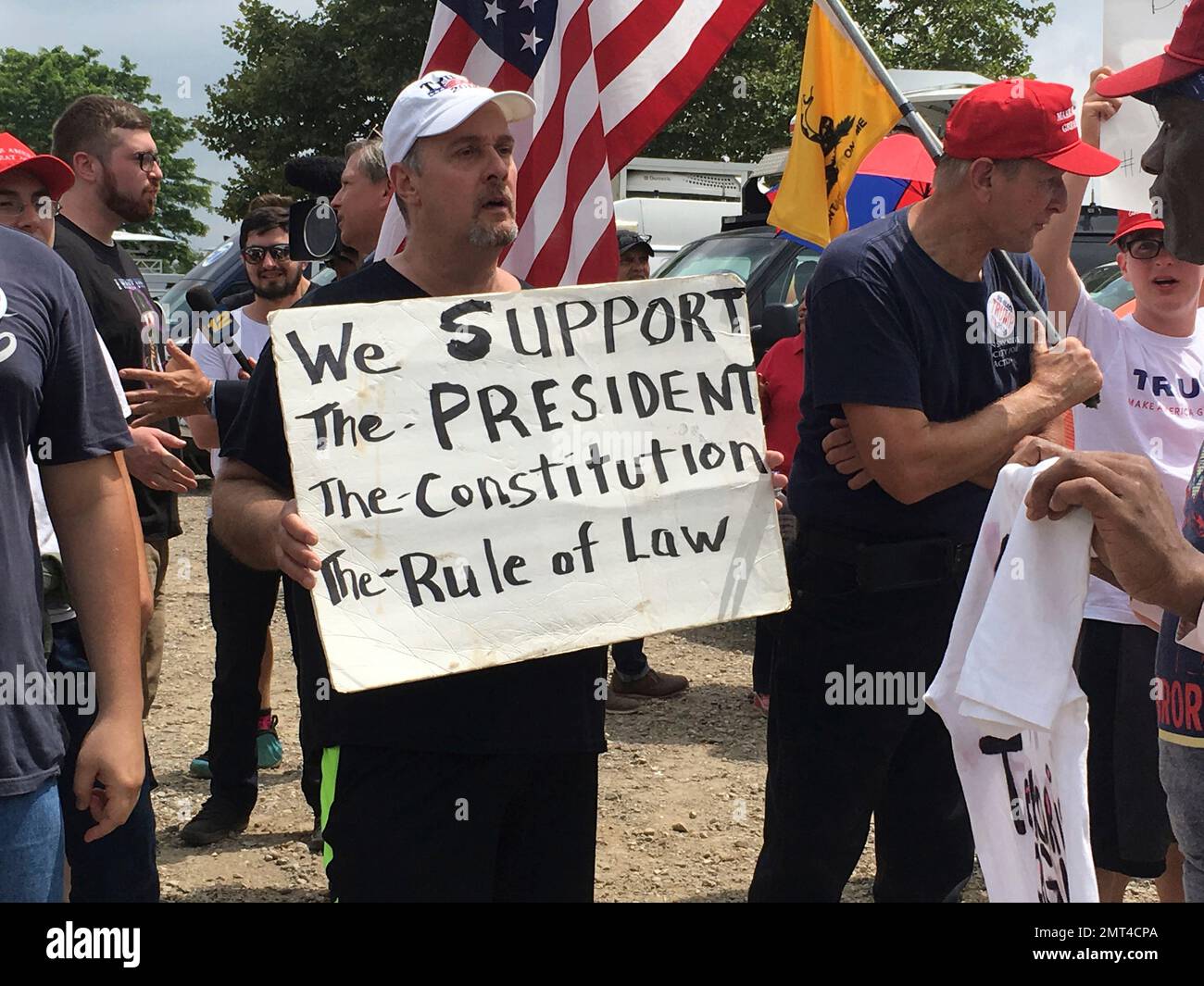 A man holds a sign supporting President Donald Trump while joining a ...