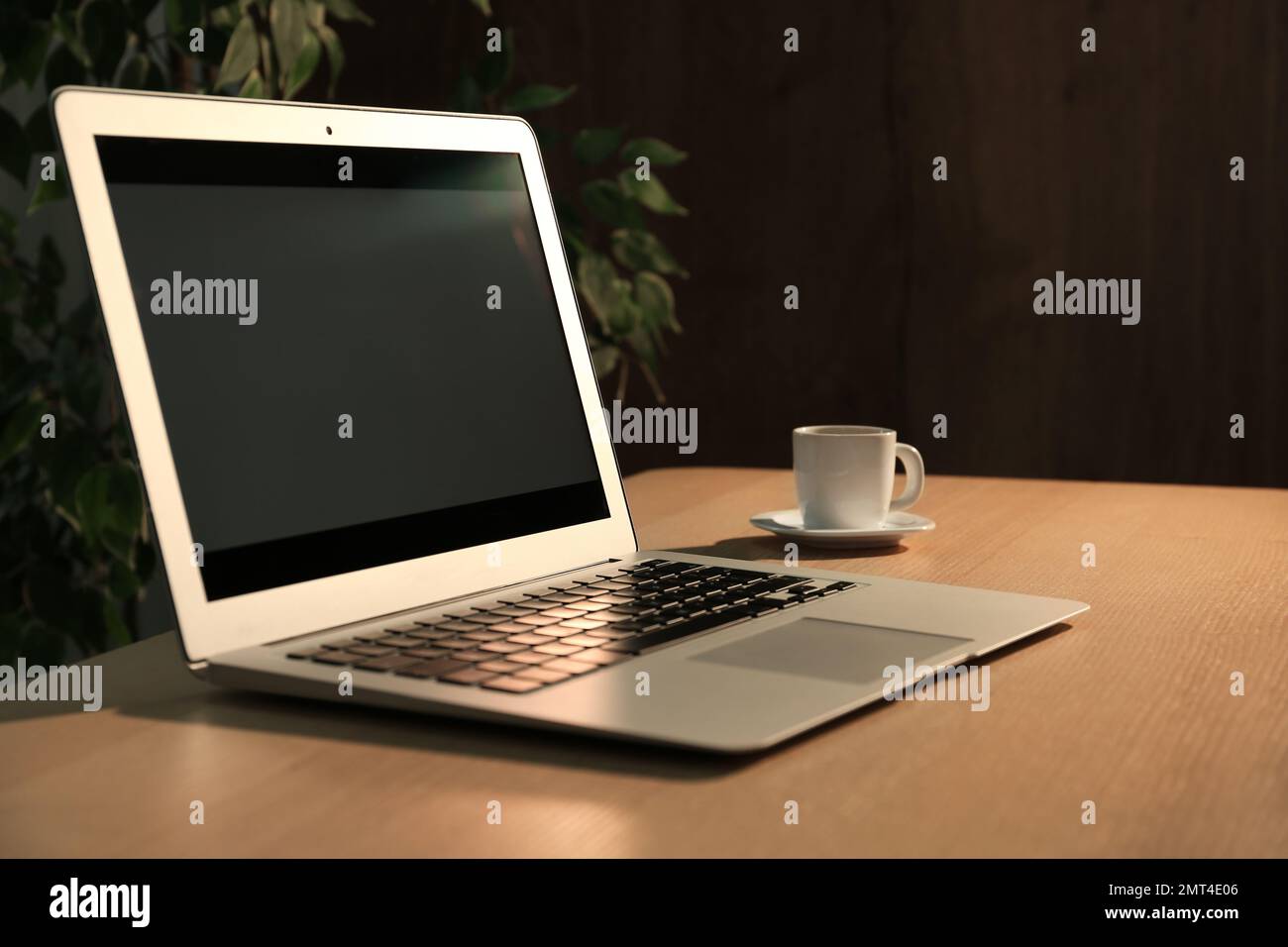 Modern laptop and cup of coffee on desk in office. Space for design ...