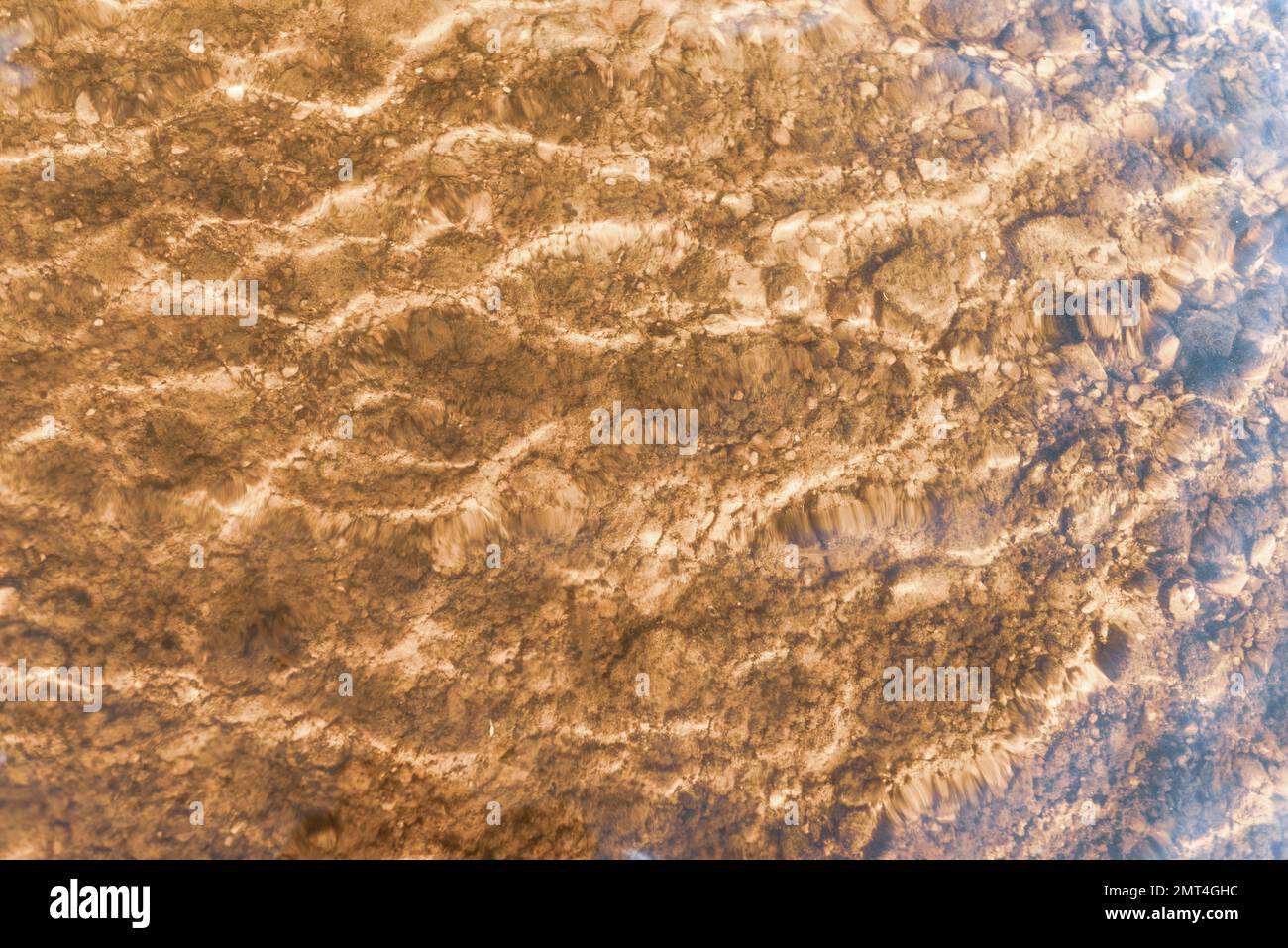 Bright reflection of the sun from the waves of transparent water. The ...