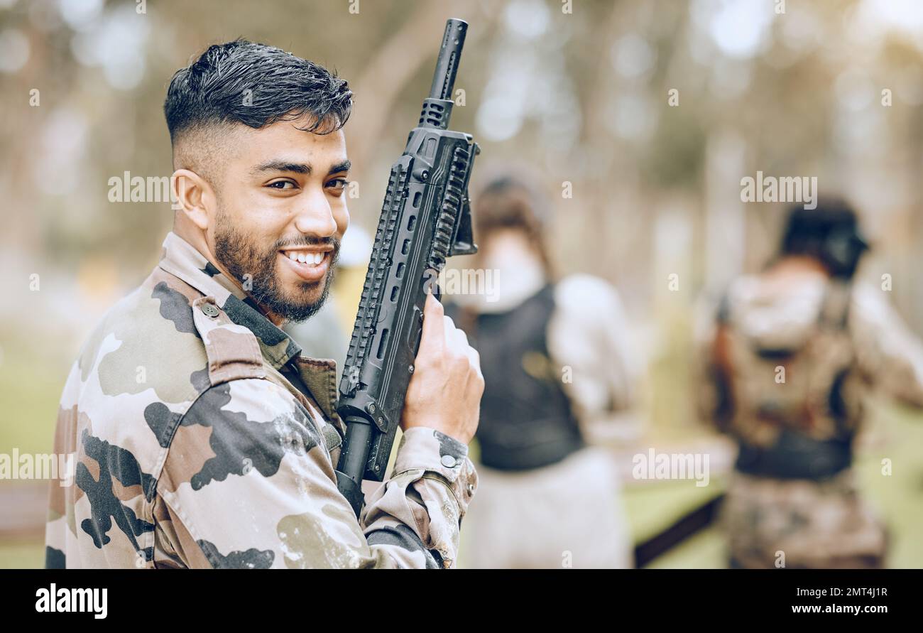 Paintball gun, man and portrait with smile, camouflage clothes and ...