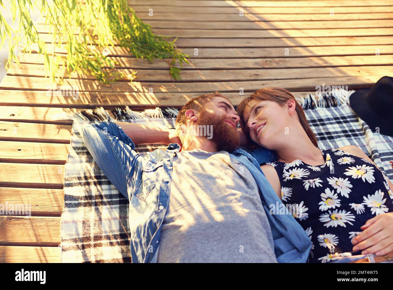 Falling in love. an affectionate young couple lying on a blanket ...