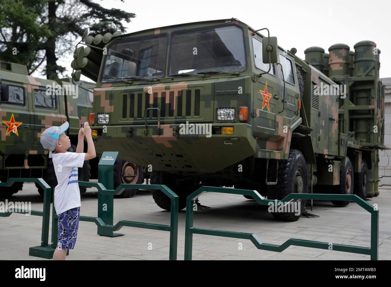 A child takes a smartphone picture of a HQ-16A medium-range air defense ...