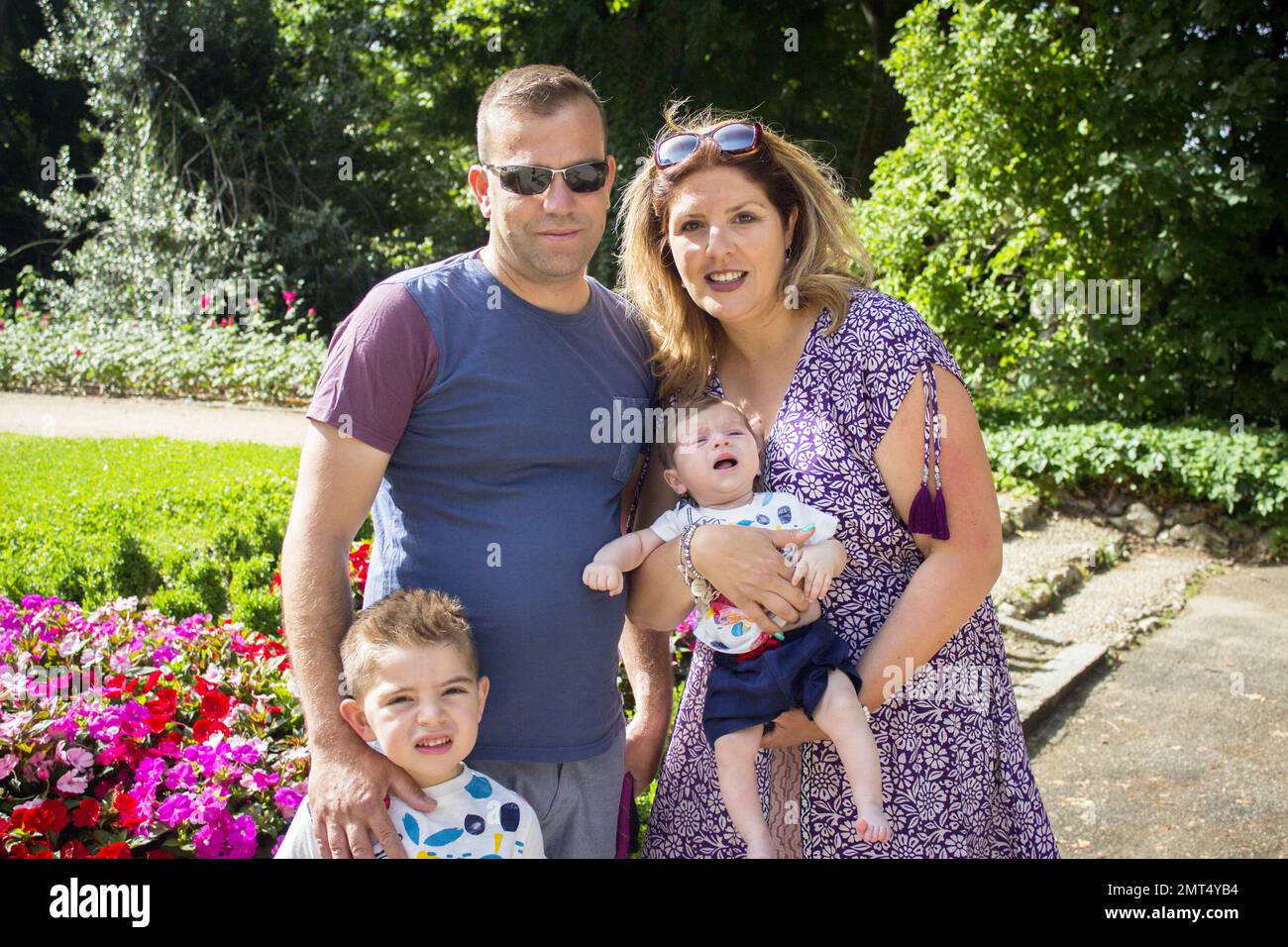 Family posing standing composed of parents, two children and a dog ...