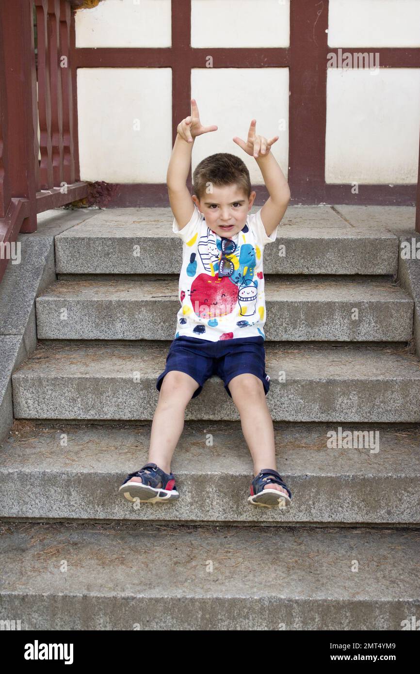 Four year old boy sitting gesturing. Alone Stock Photo - Alamy