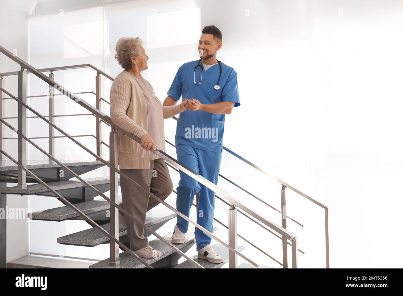 Doctor helping senior patient in modern hospital Stock Photo - Alamy