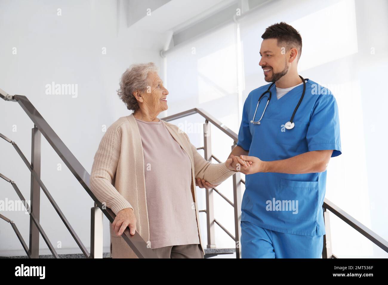Doctor helping senior patient in modern hospital Stock Photo - Alamy