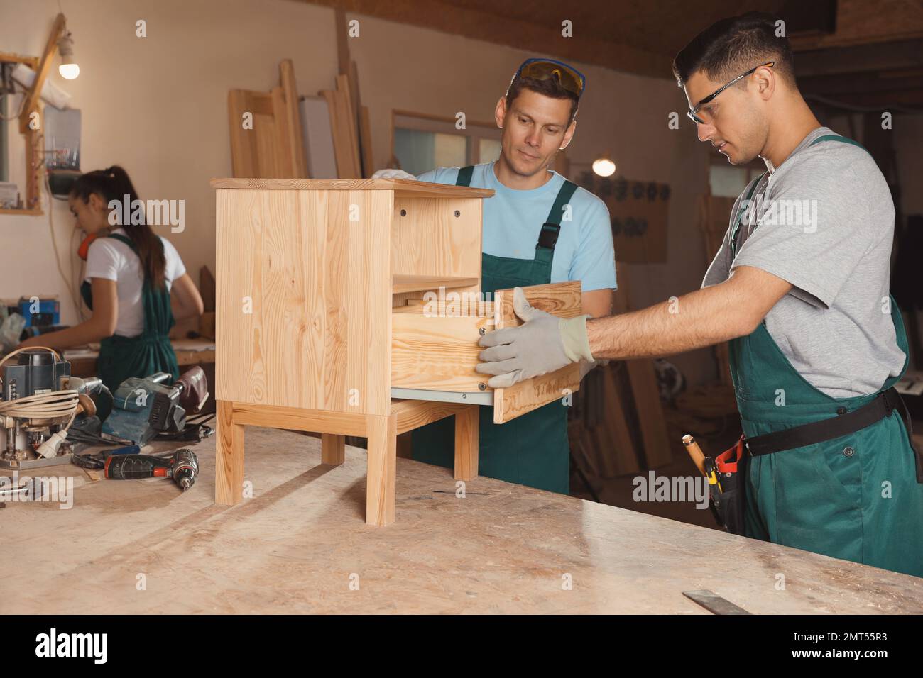Professional carpenters assembling wooden cabinet in workshop Stock Photo - Alamy