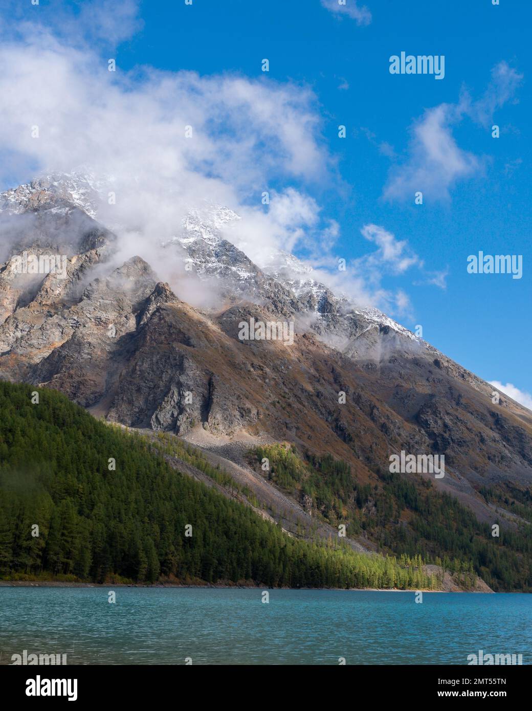 Snowy mountains of turquoise lake Shavlinskoe surrounded by rocks with ...