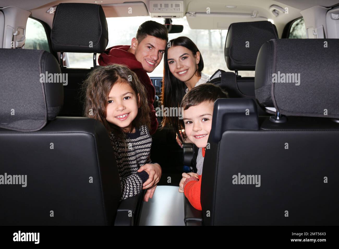 Happy family with little children inside modern car Stock Photo - Alamy