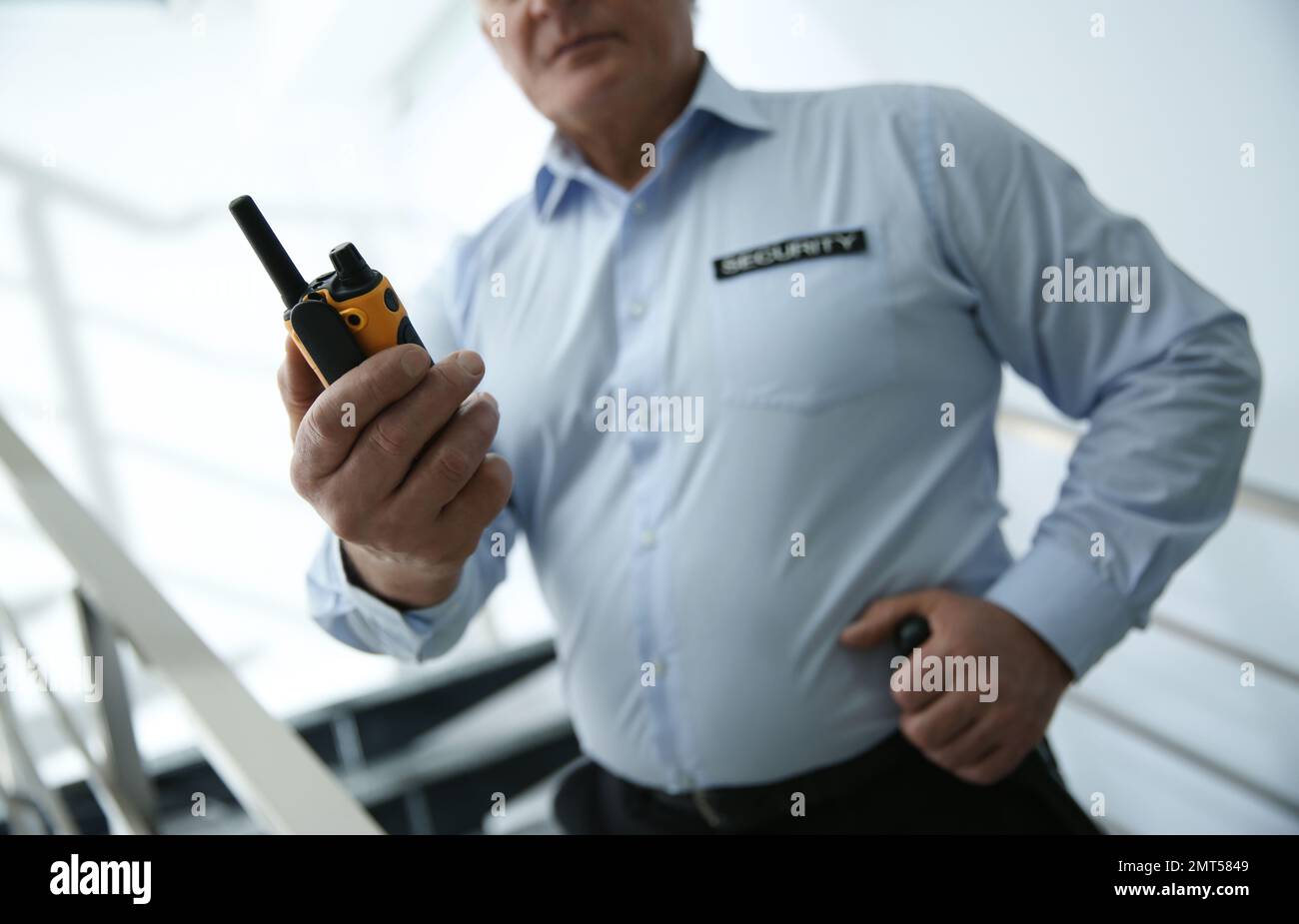 Professional security guard with portable radio set on stairs, closeup ...