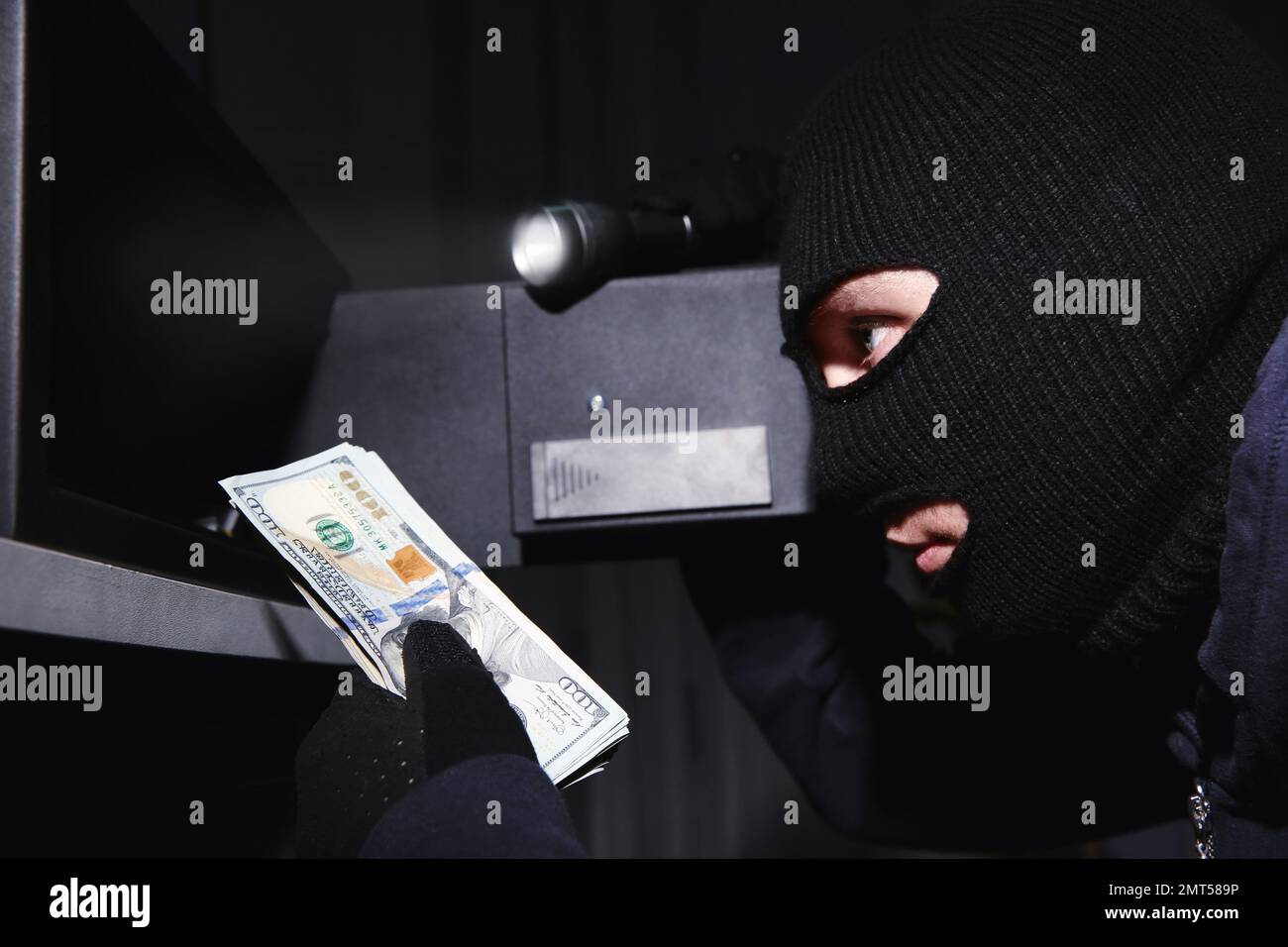 Thief taking money out of steel safe indoors at night, closeup Stock ...
