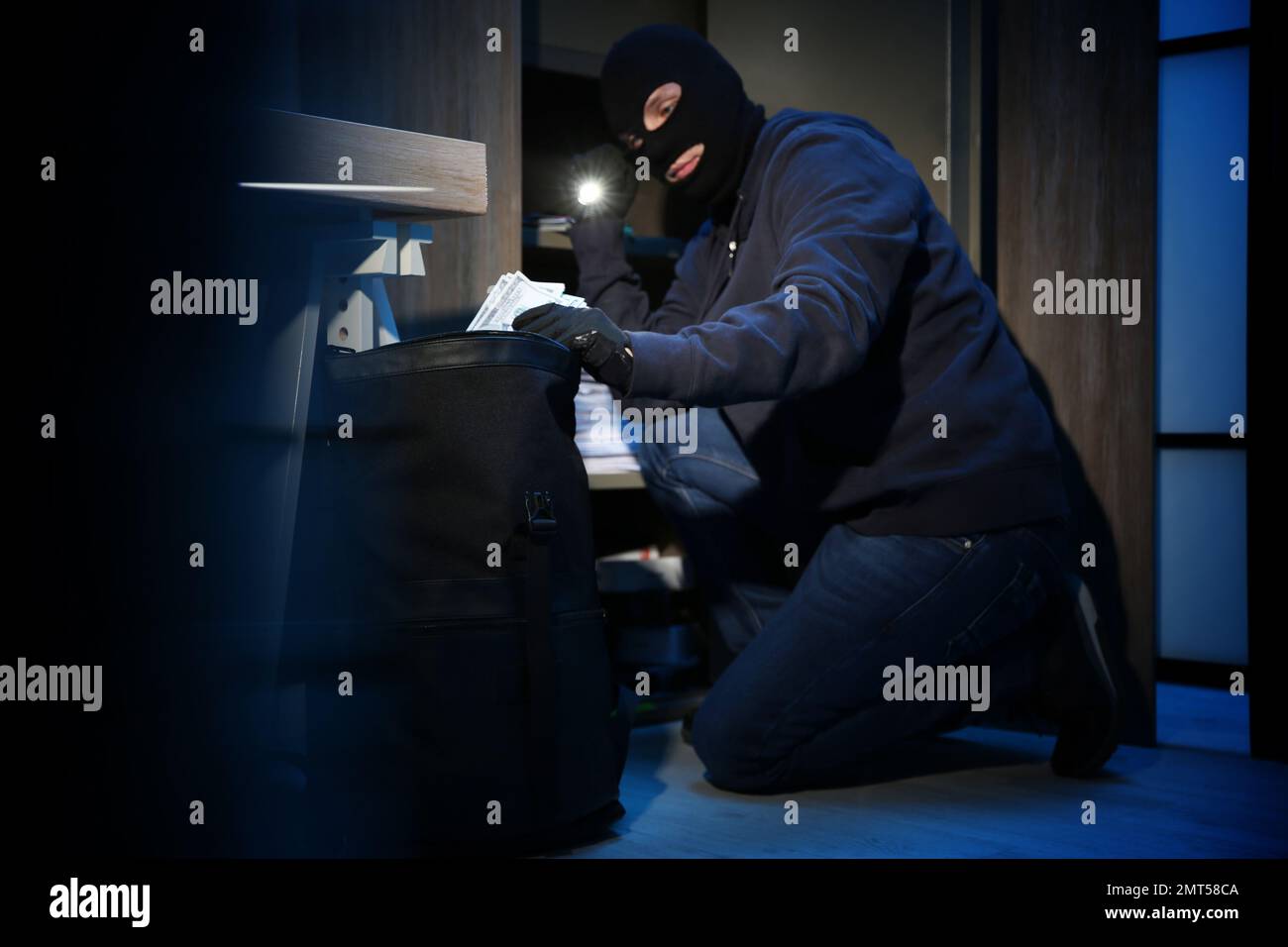 Thief taking money out of steel safe indoors at night Stock Photo - Alamy